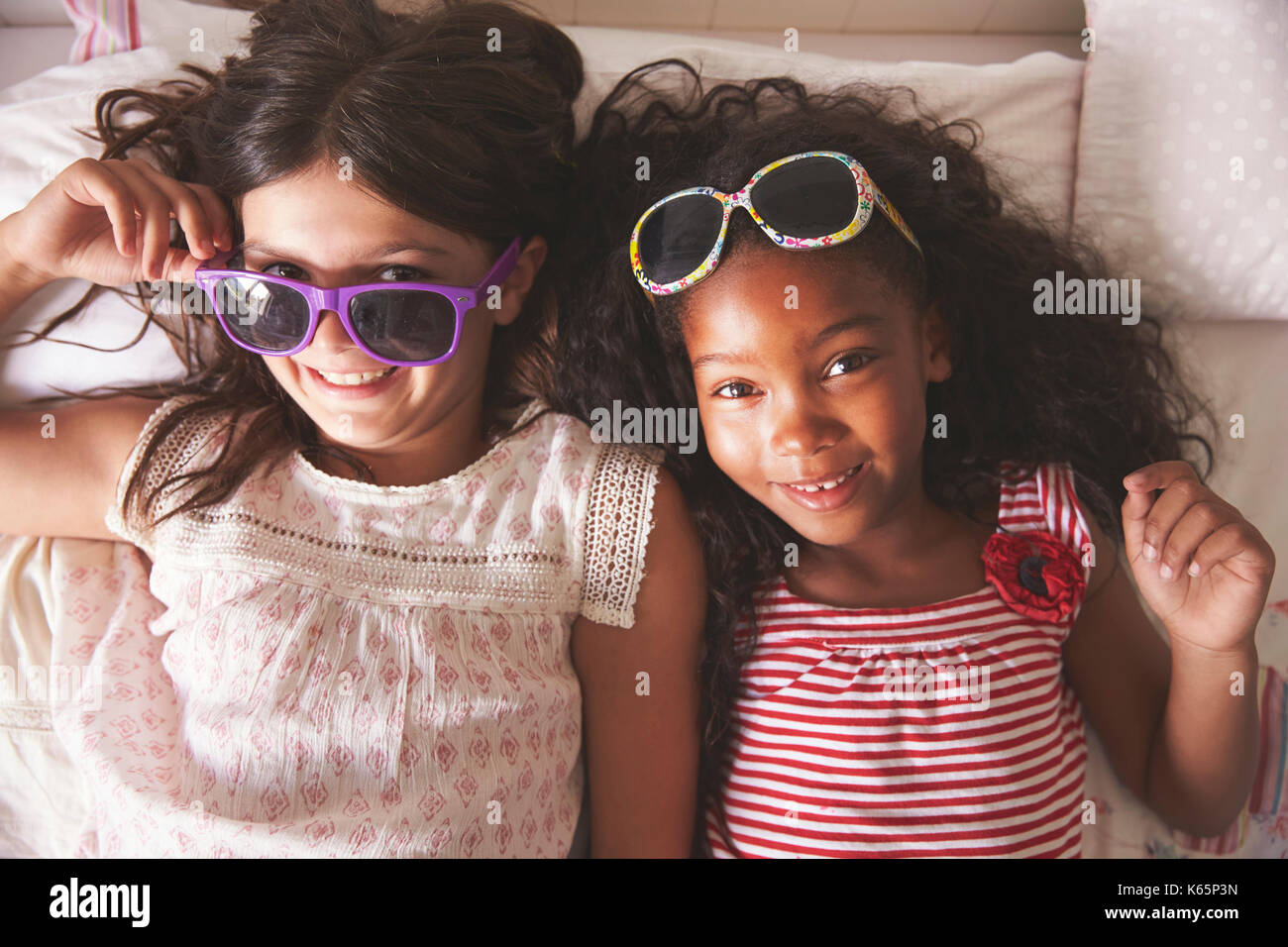 Portrait Of Two Girls Wearing Sunglasses In Bedroom Together Stock ...