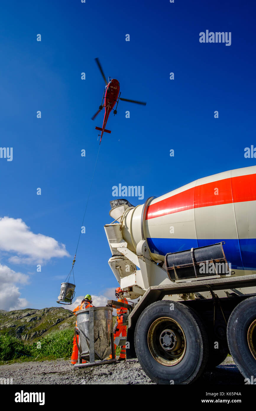 A helicopter of the company Swiss Helicopters is transporting concrete ...