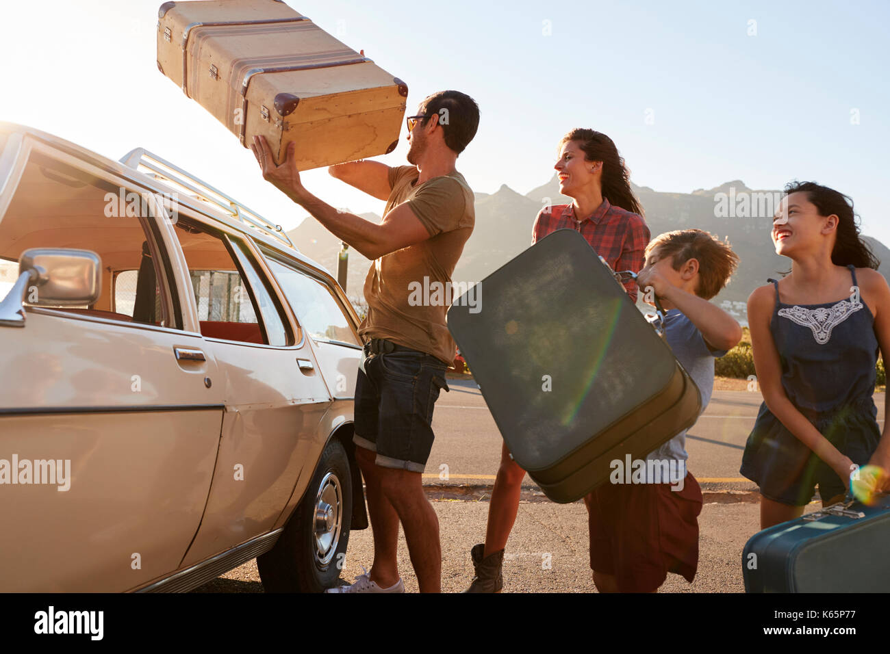 Family Loading Luggage Onto Car Roof Rack Ready For Road Trip Stock ...