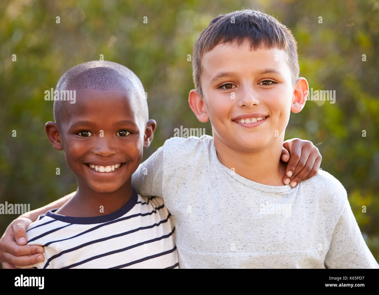 Two boys with arms around each other hi-res stock photography and ...