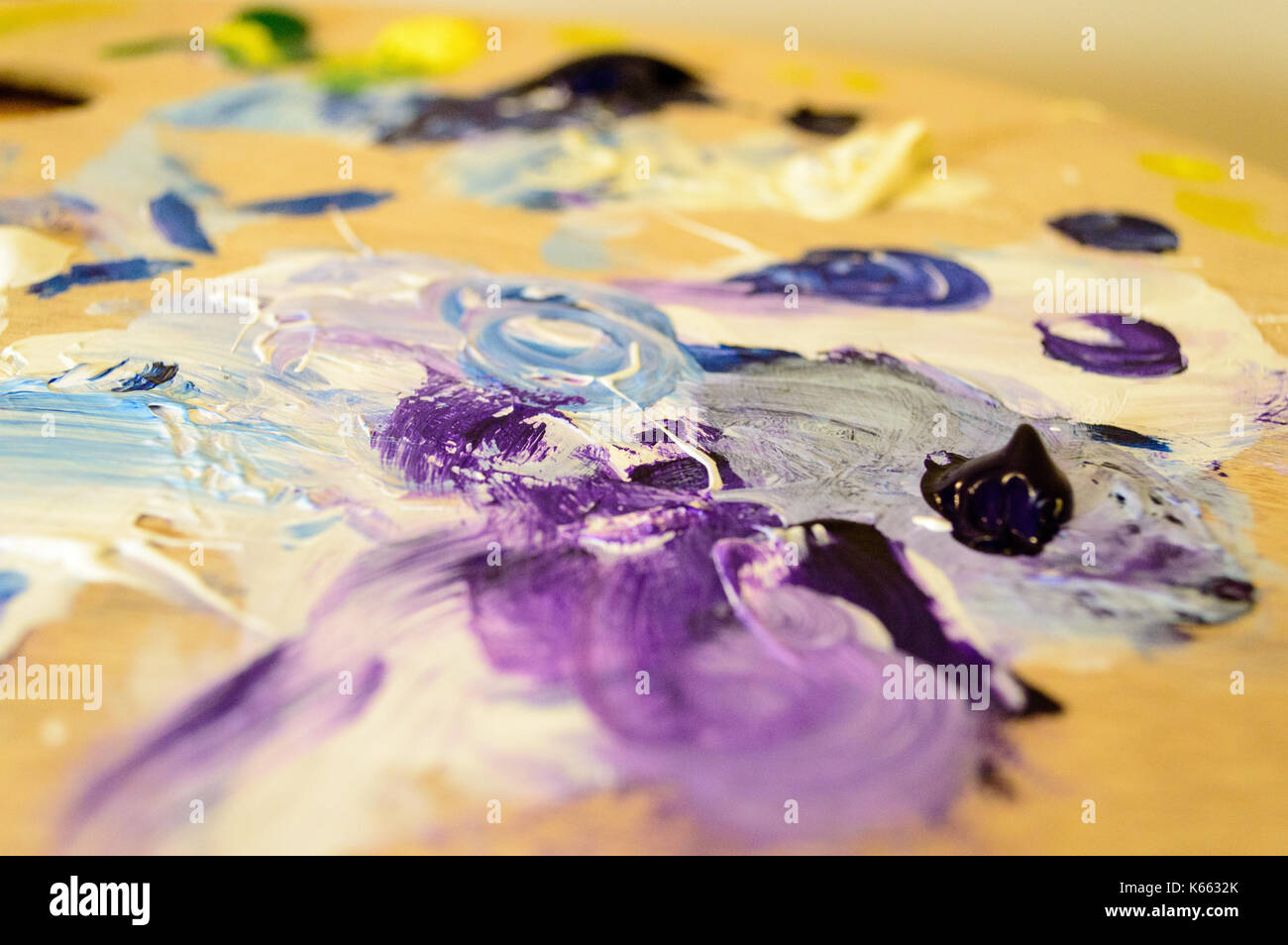 artist painting with acrylic colors and mixing tones on the pallet ...