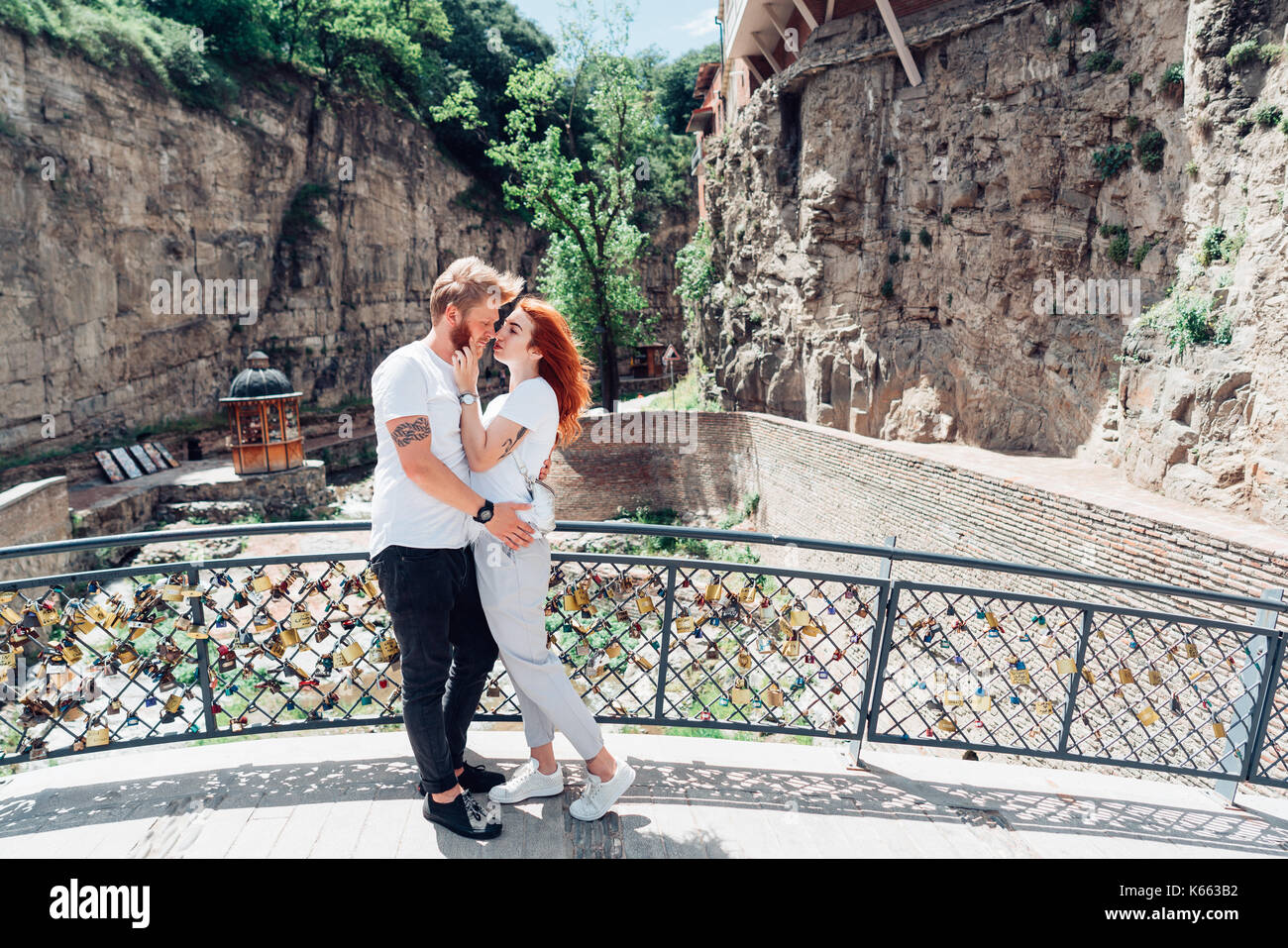 Guy with a girl standing on bridge Stock Photo - Alamy