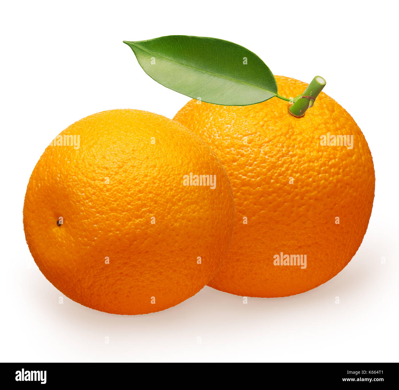 Whole fresh orange fruit with green leaf next to orange lying on its ...