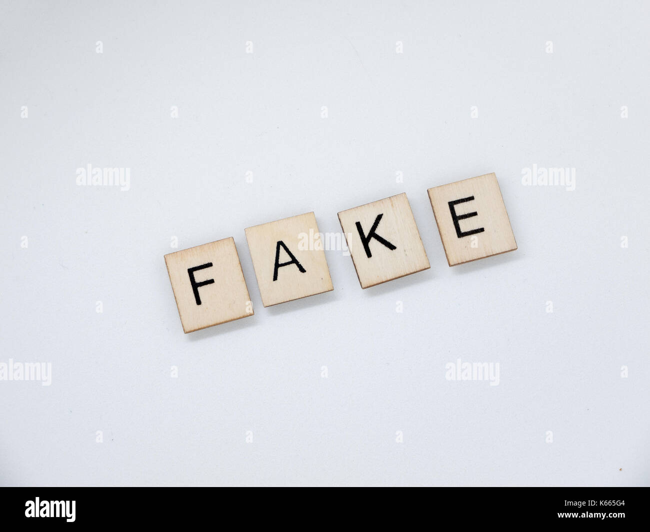 The word "Fake" spelled out with wooden letter tiles Stock Photo - Alamy