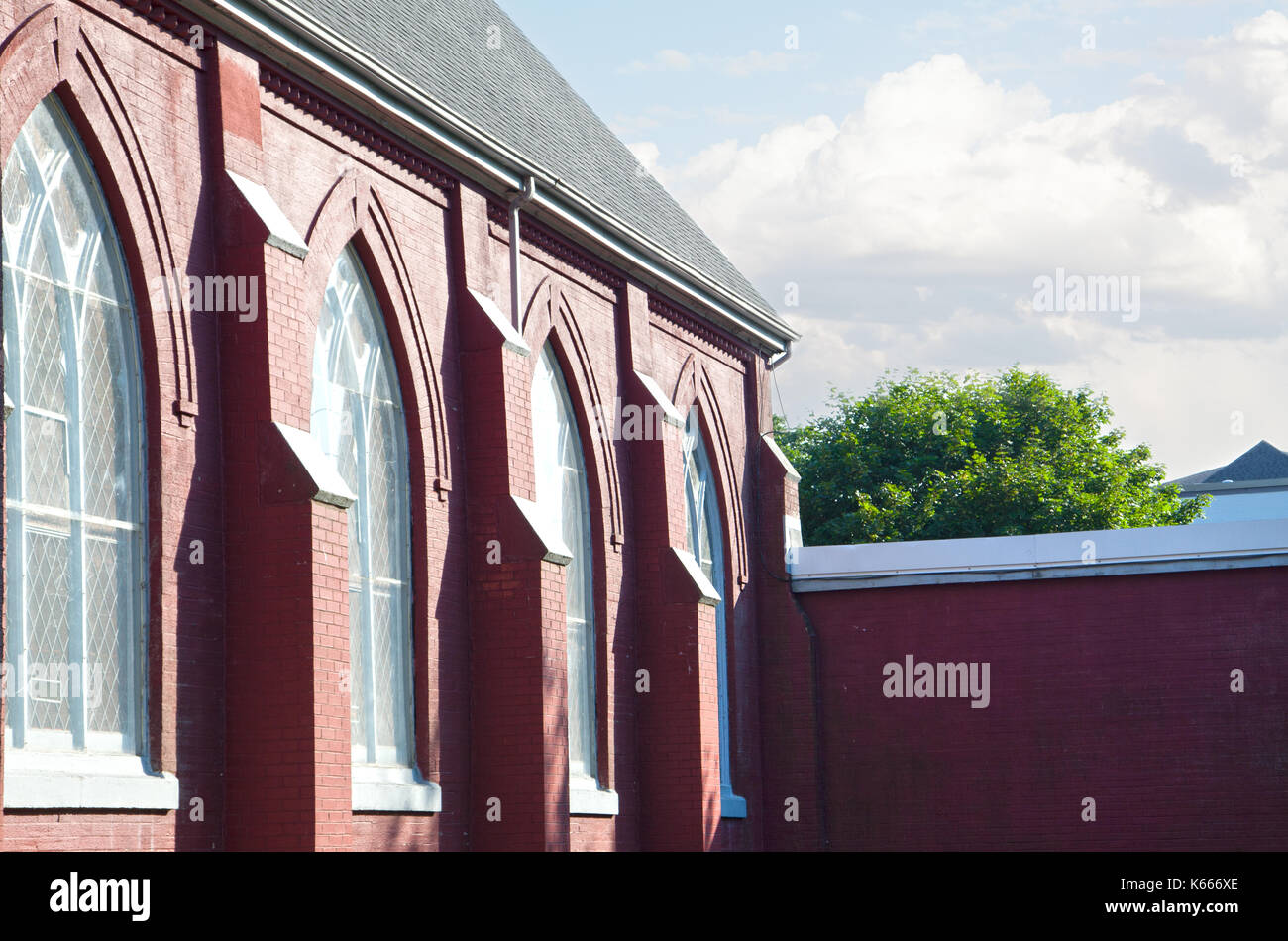 side of red brick church with glass windows and blue sky Stock Photo ...