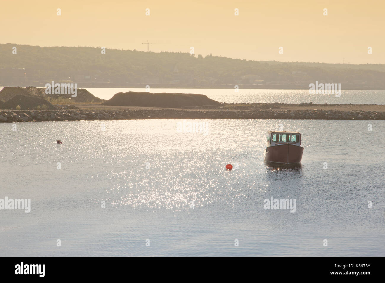 a small red boat in a harbor at sunset Stock Photo - Alamy