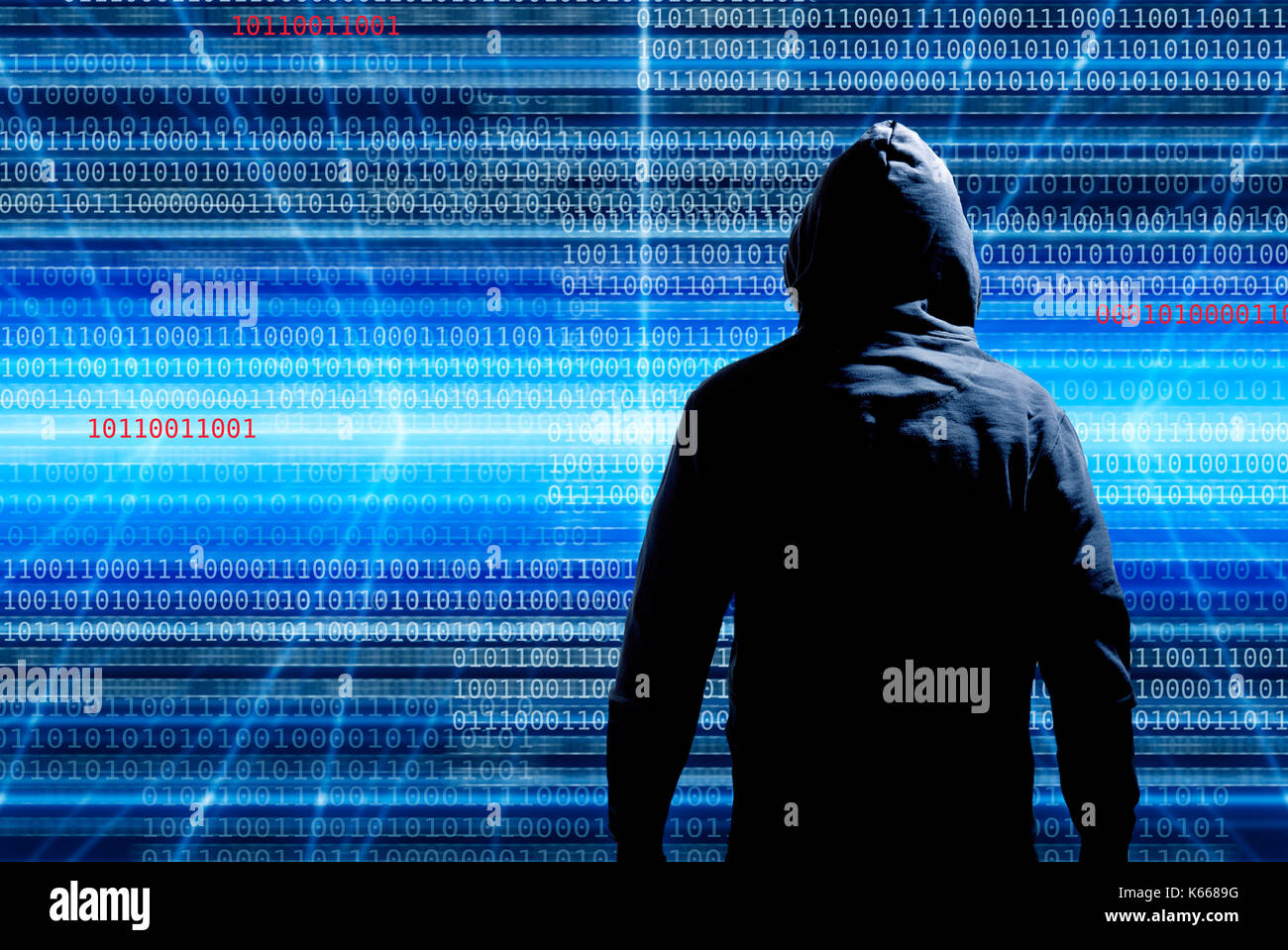 hacker wearing a hoodie in front of a computer code background Stock ...