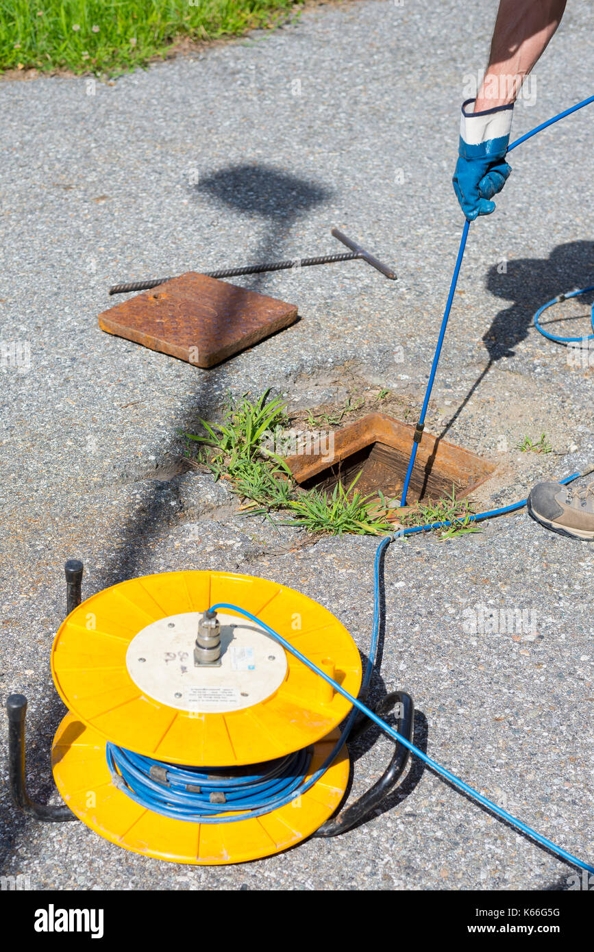 Geologist taking inclinometer readings on road, measuring slope ...