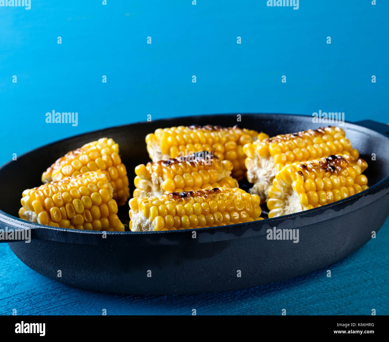Baked on a frying pan corn. Blue background. The concept of healthy ...