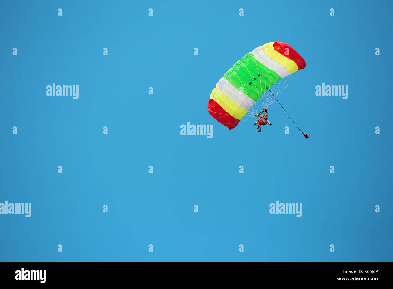 Two people on a multi-colored parachute in the sky. The concept of ...