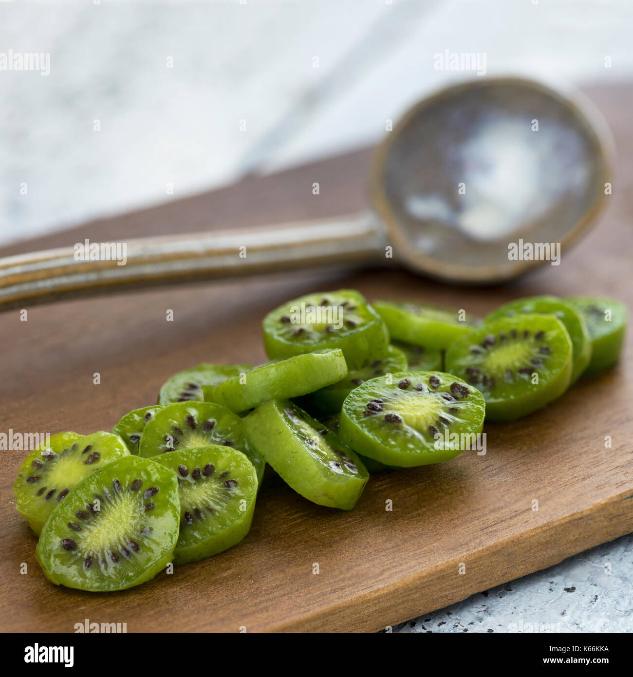 square image of mini kiwi berries shot with macro on a dark wooden ...