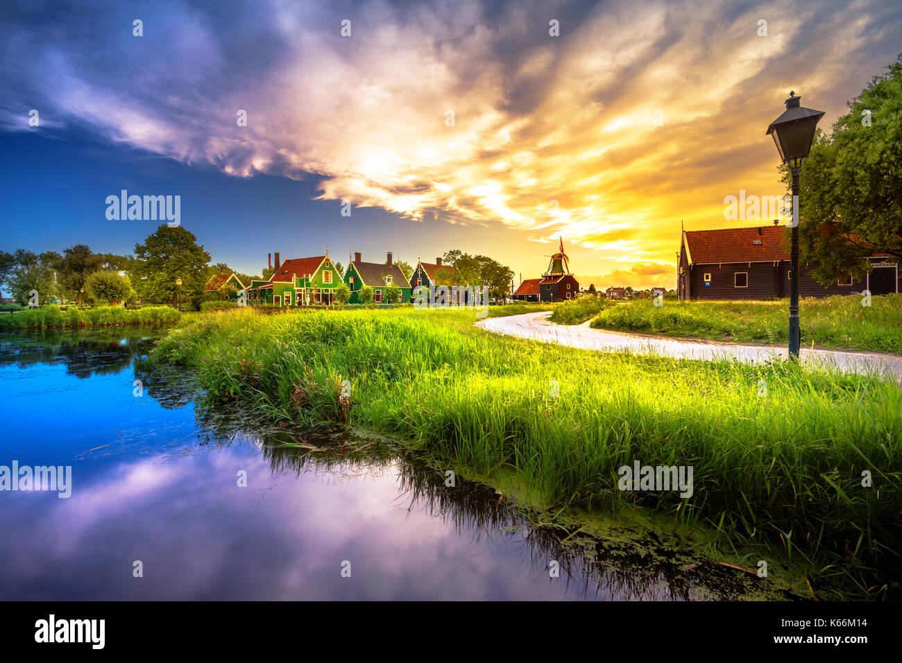 Traditional village with dutch windmills and river at sunset, Holland ...