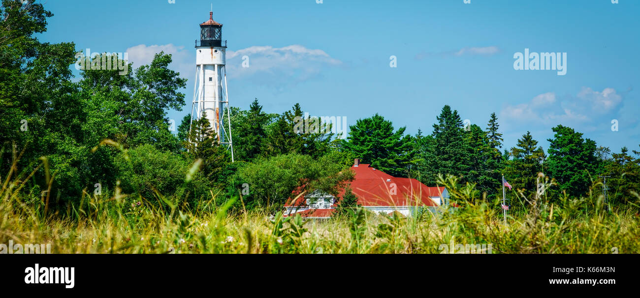 A Wisconsin lighthouse rises out of the forest looking over Lake ...