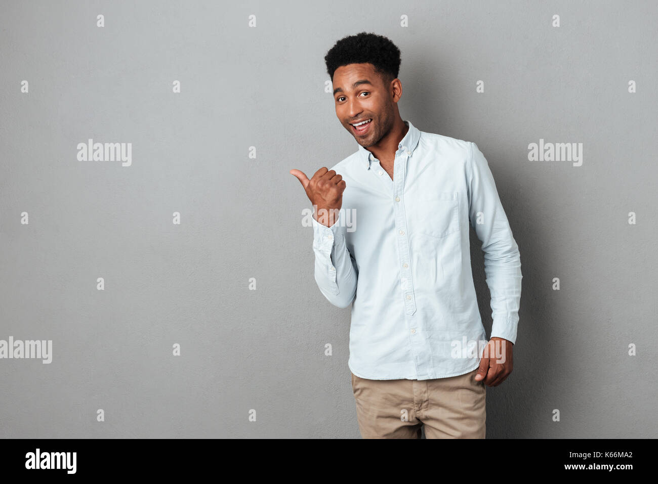 Happy excited african man pointing finger away at copy space isolated ...