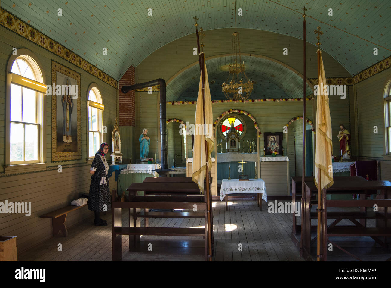 A historic reenactor stand by a stained glass window in a historic ...