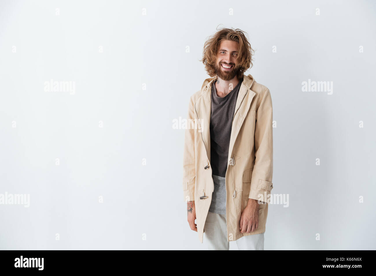 Image of caucasian young happy bearded man standing isolated over grey ...