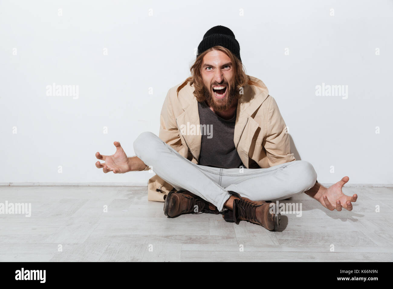 Portrait of a screaming angry hipster guy looking camera sitting ...