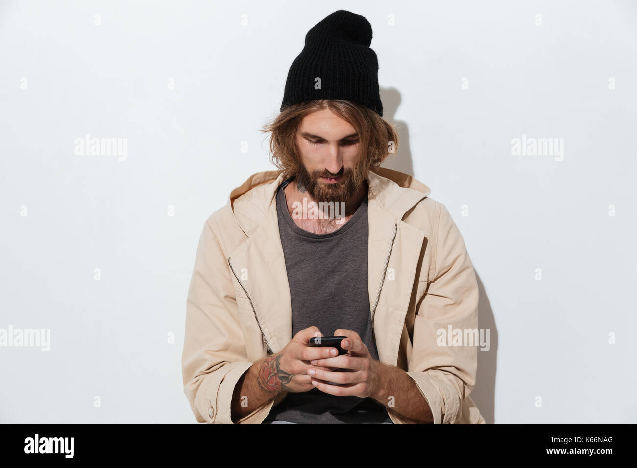 Image of a handsome hipster man looking aside sitting isolated over ...