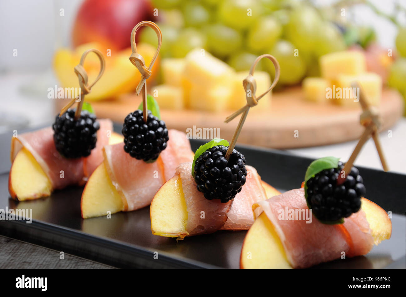 Canape from peach with dried ham and blackberries Stock Photo - Alamy