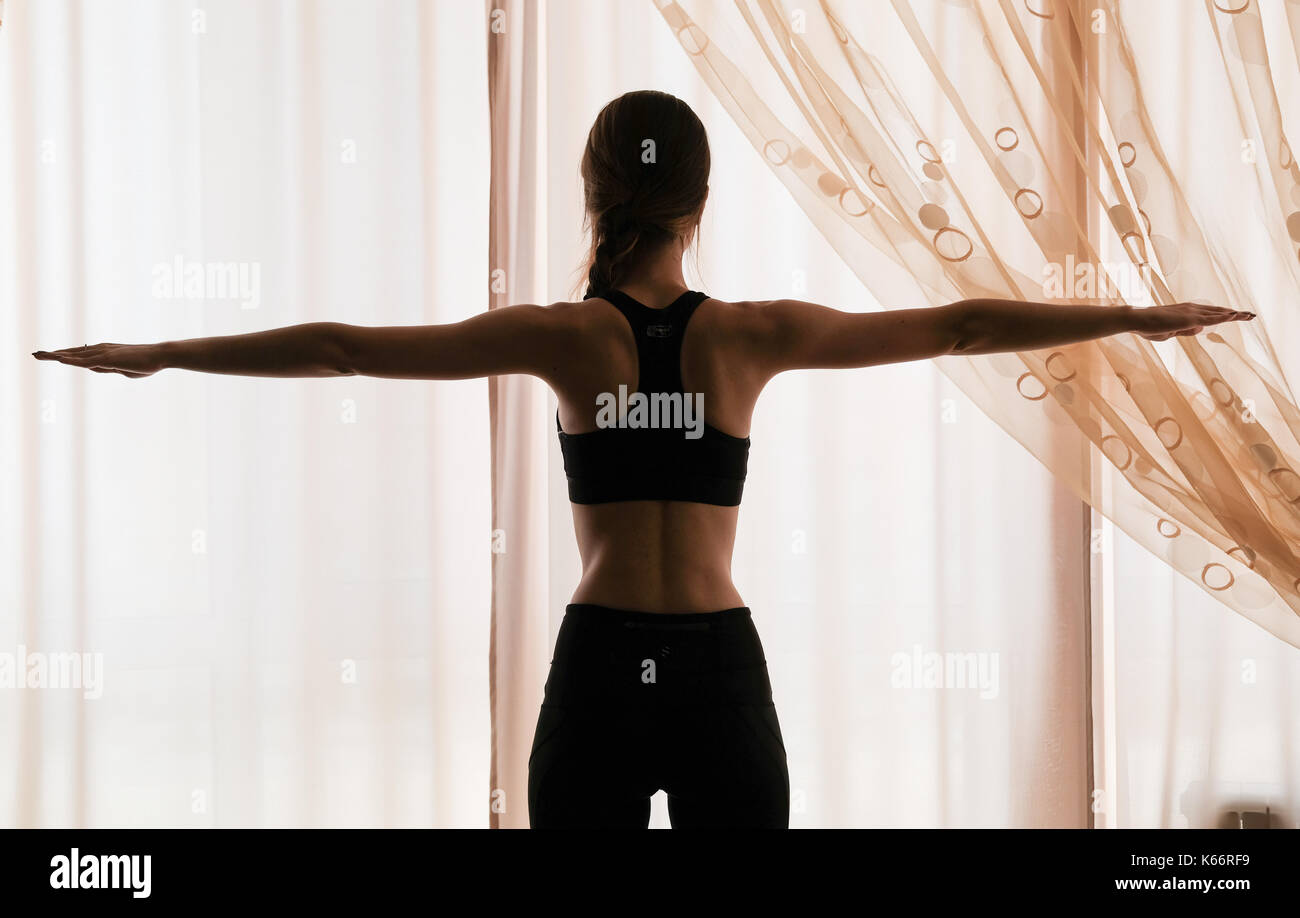Attractive Girl in Yoga Pose by Window - tibetan yoga Stock Photo - Alamy