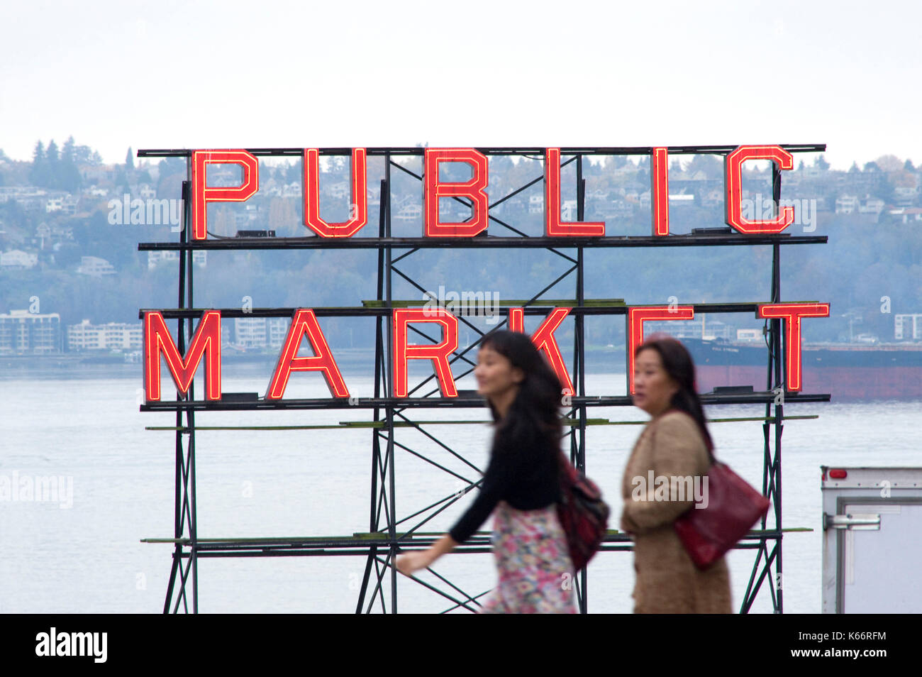 2 Asian ladies walk past the Public Market sign in Pike Place Market ...