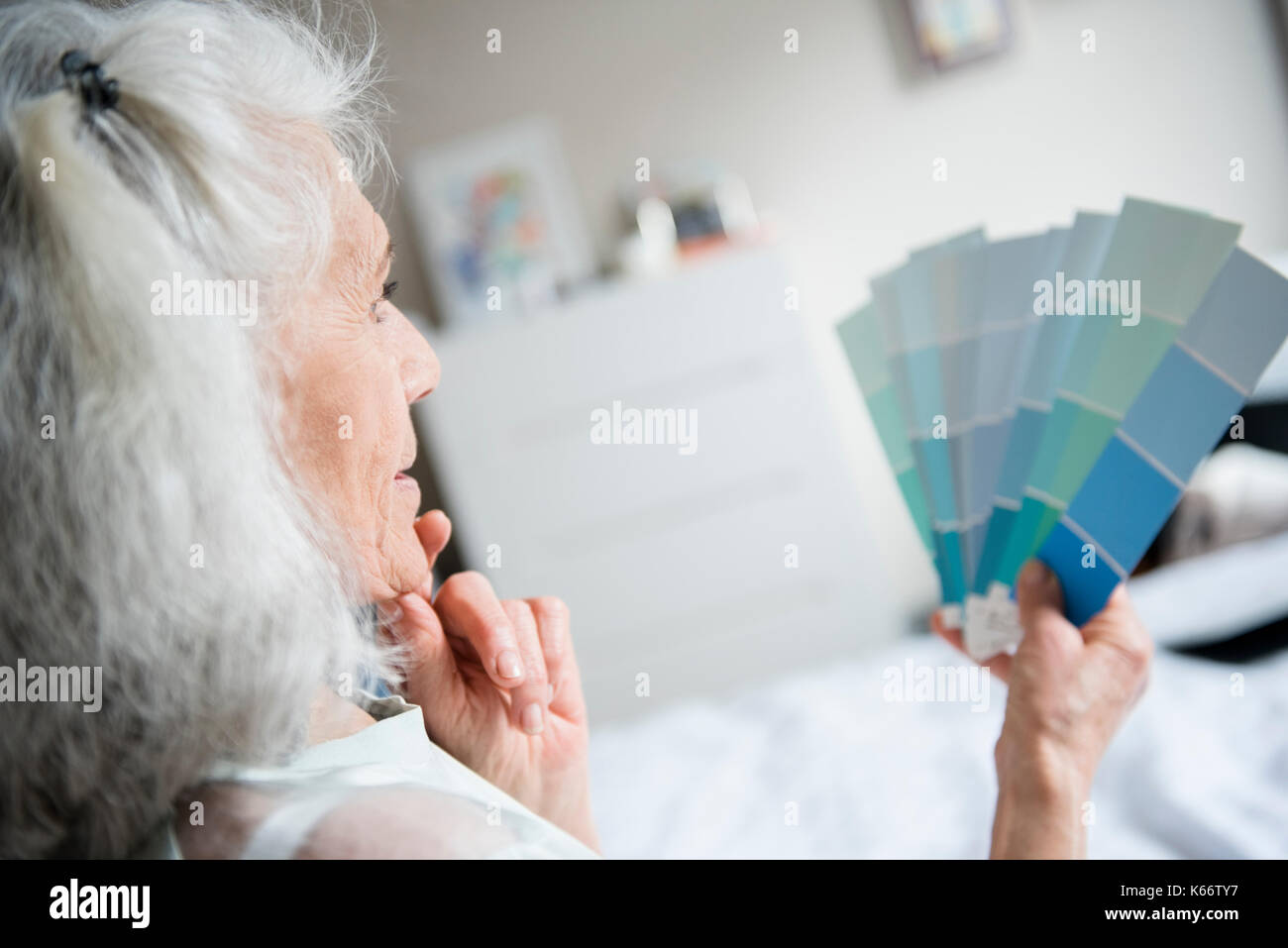 Pensive older woman examining color swatches Stock Photo - Alamy