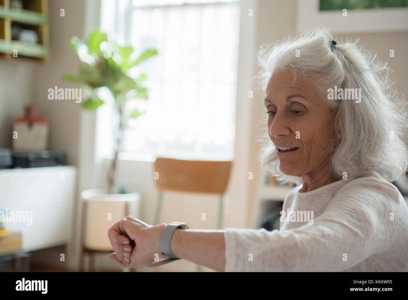 Older woman checking wristwatch Stock Photo - Alamy