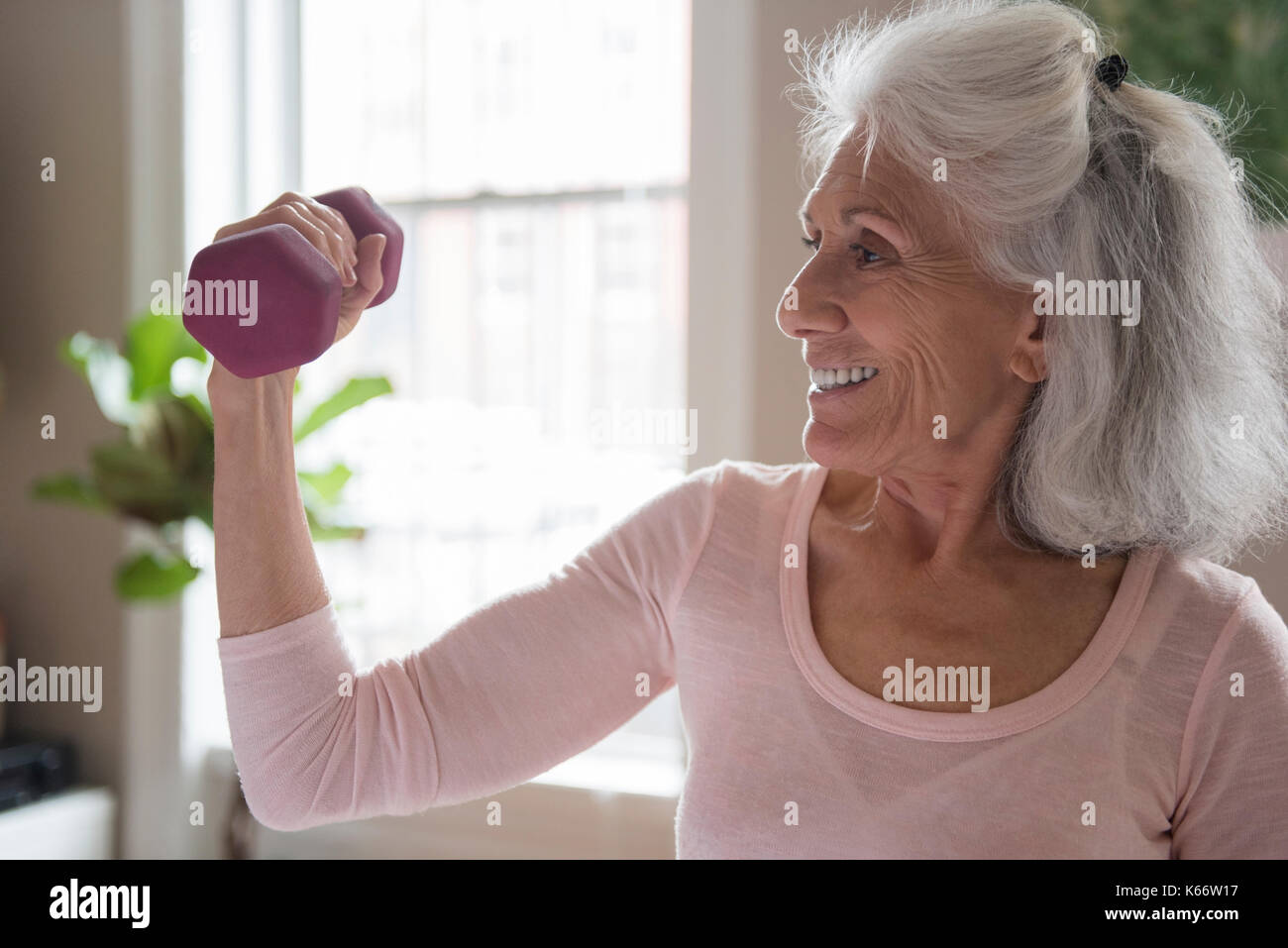 Smiling older woman lifting weights Stock Photo - Alamy