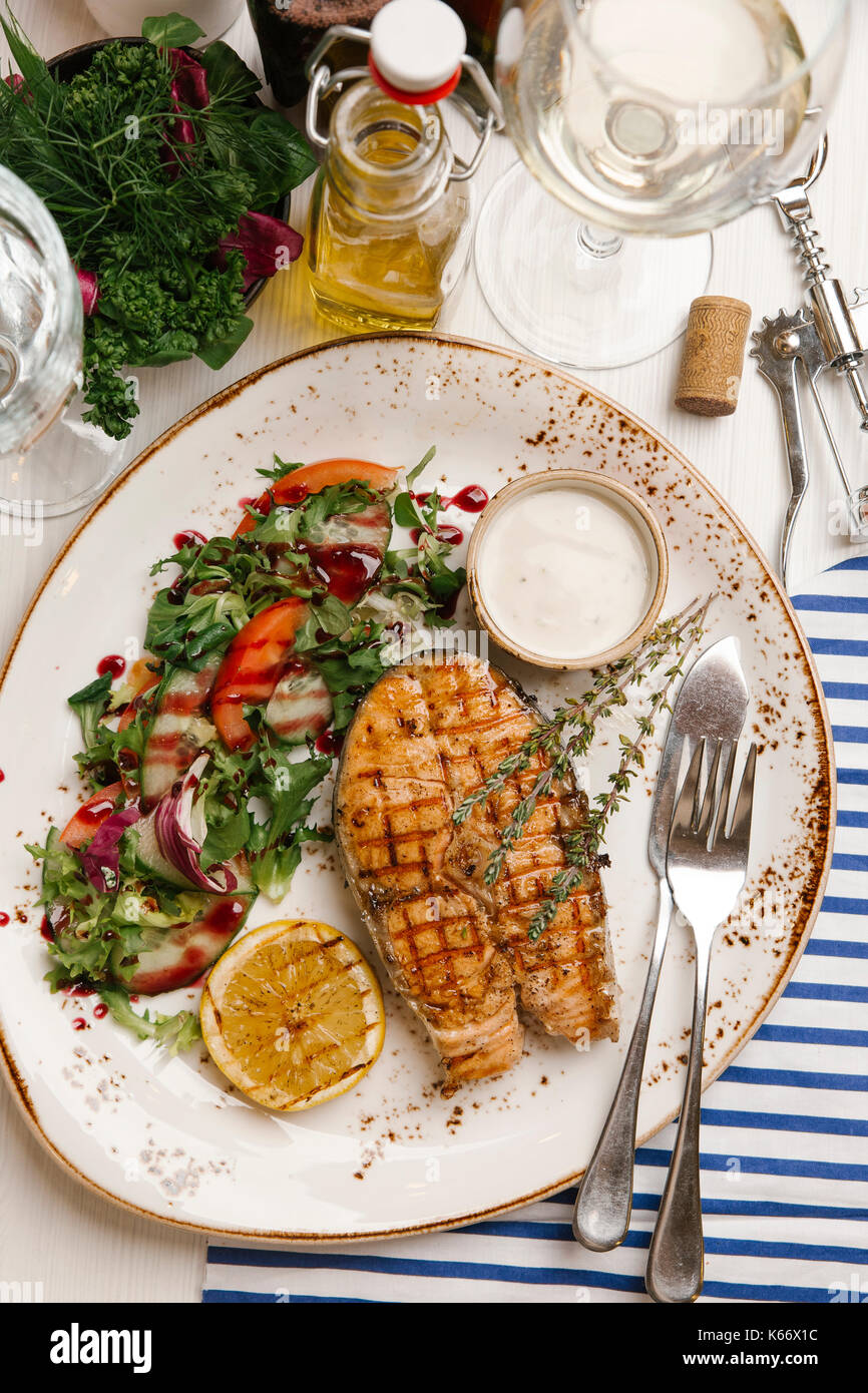 Grilled fish and salad on plate with sauce Stock Photo - Alamy
