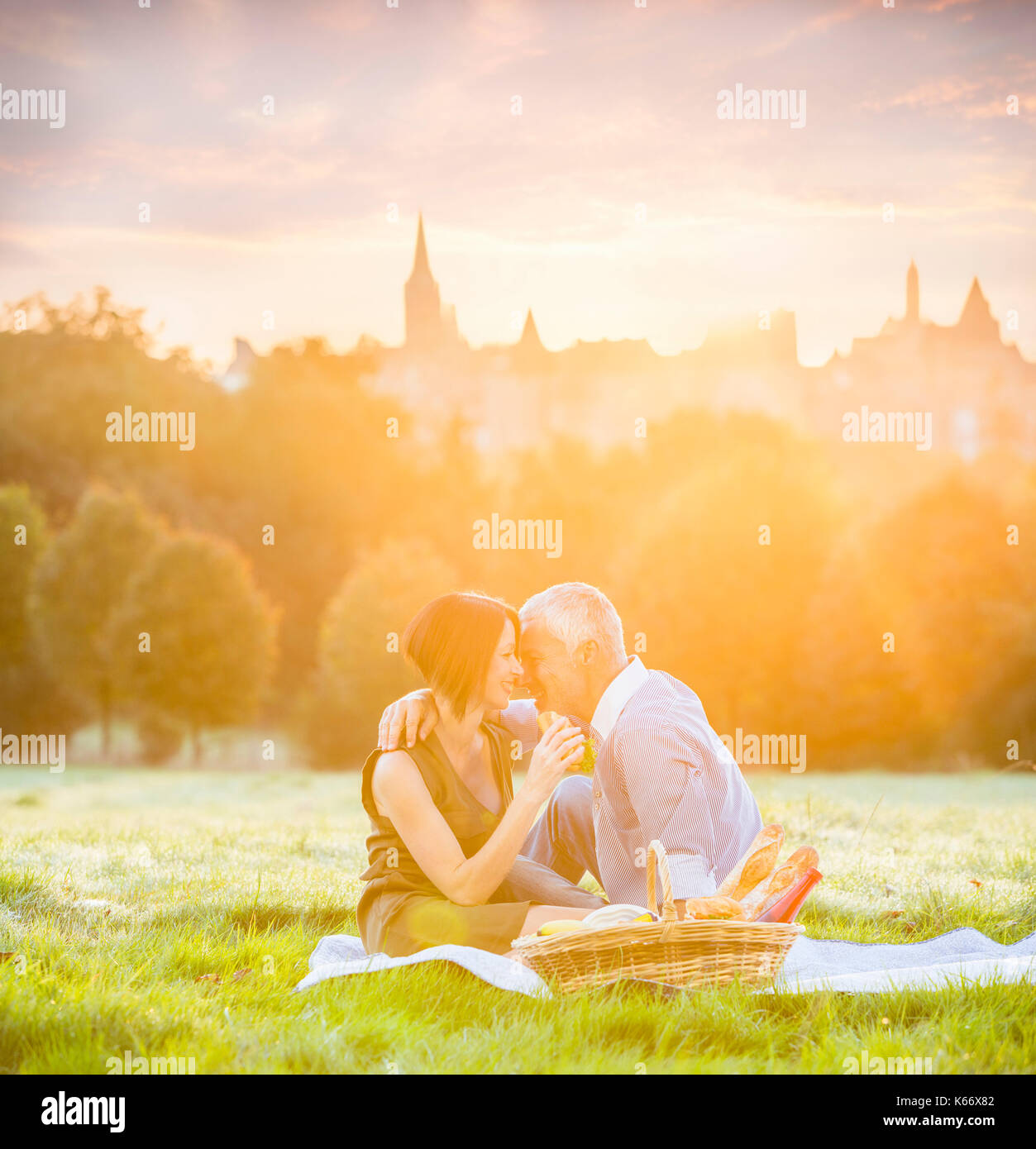 Caucasian couple enjoying picnic in grass Stock Photo - Alamy