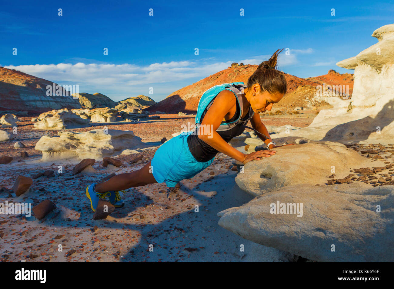 Native American woman doing push-up on rock in desert Stock Photo - Alamy