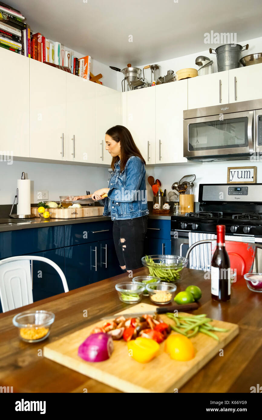 Woman chopping vegetables in kitchen Stock Photo - Alamy
