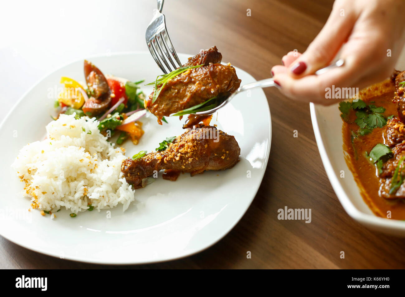 Woman holding meat over plate with fork and spoon Stock Photo - Alamy