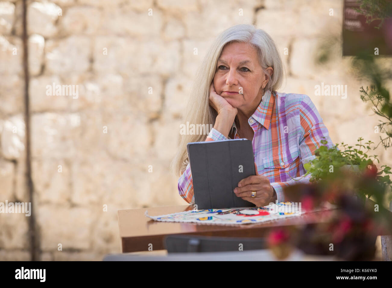 Pensive older Caucasian woman using digital tablet Stock Photo - Alamy