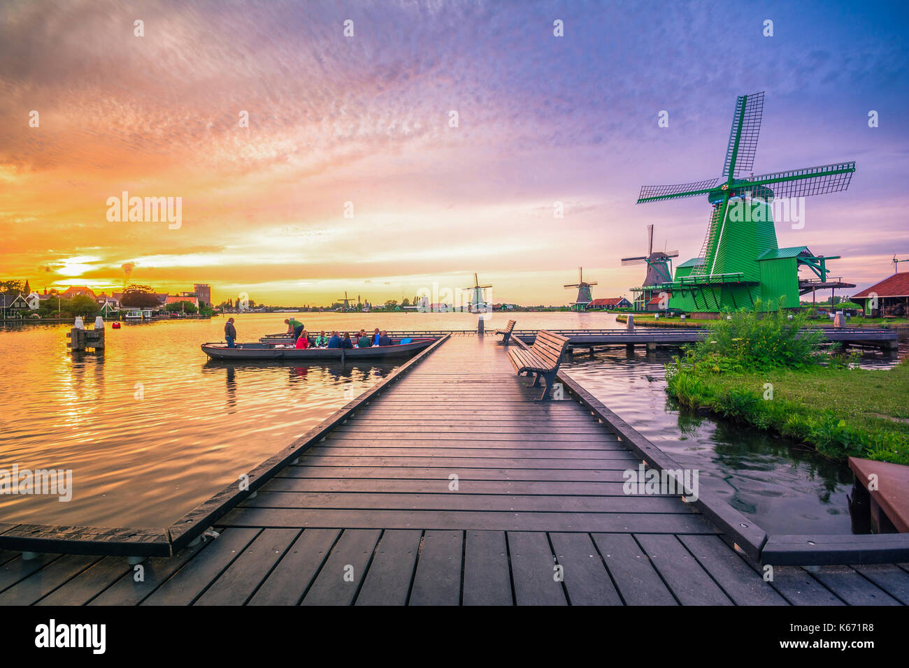 Traditional village with dutch windmills and river at sunset, Holland ...