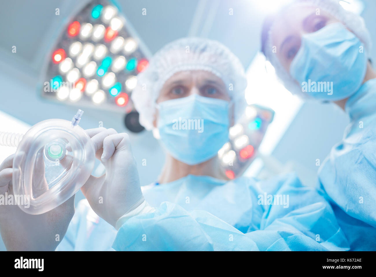 Two doctors standing over patient Stock Photo - Alamy