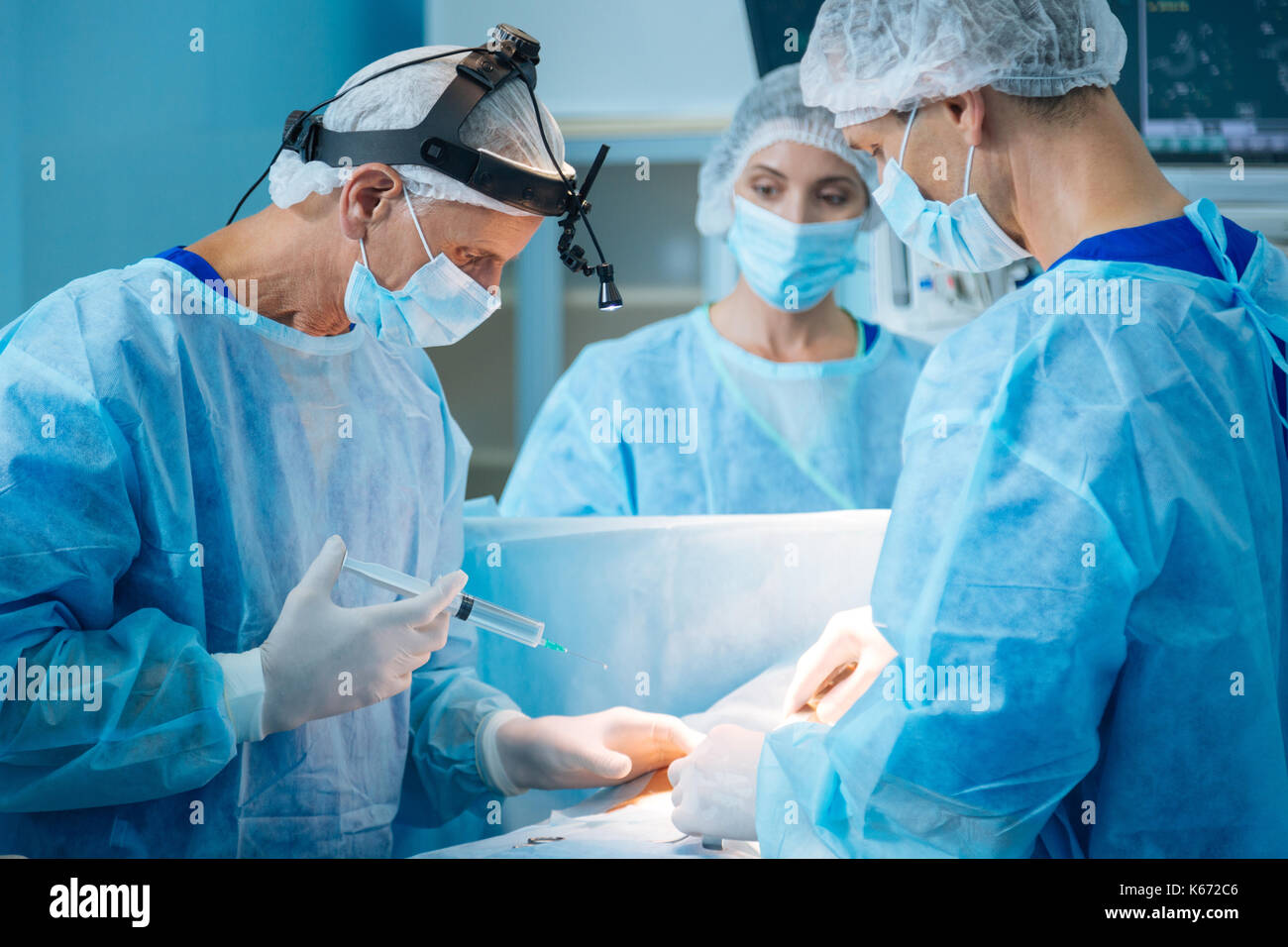 Competent senior surgeon doing injection Stock Photo - Alamy