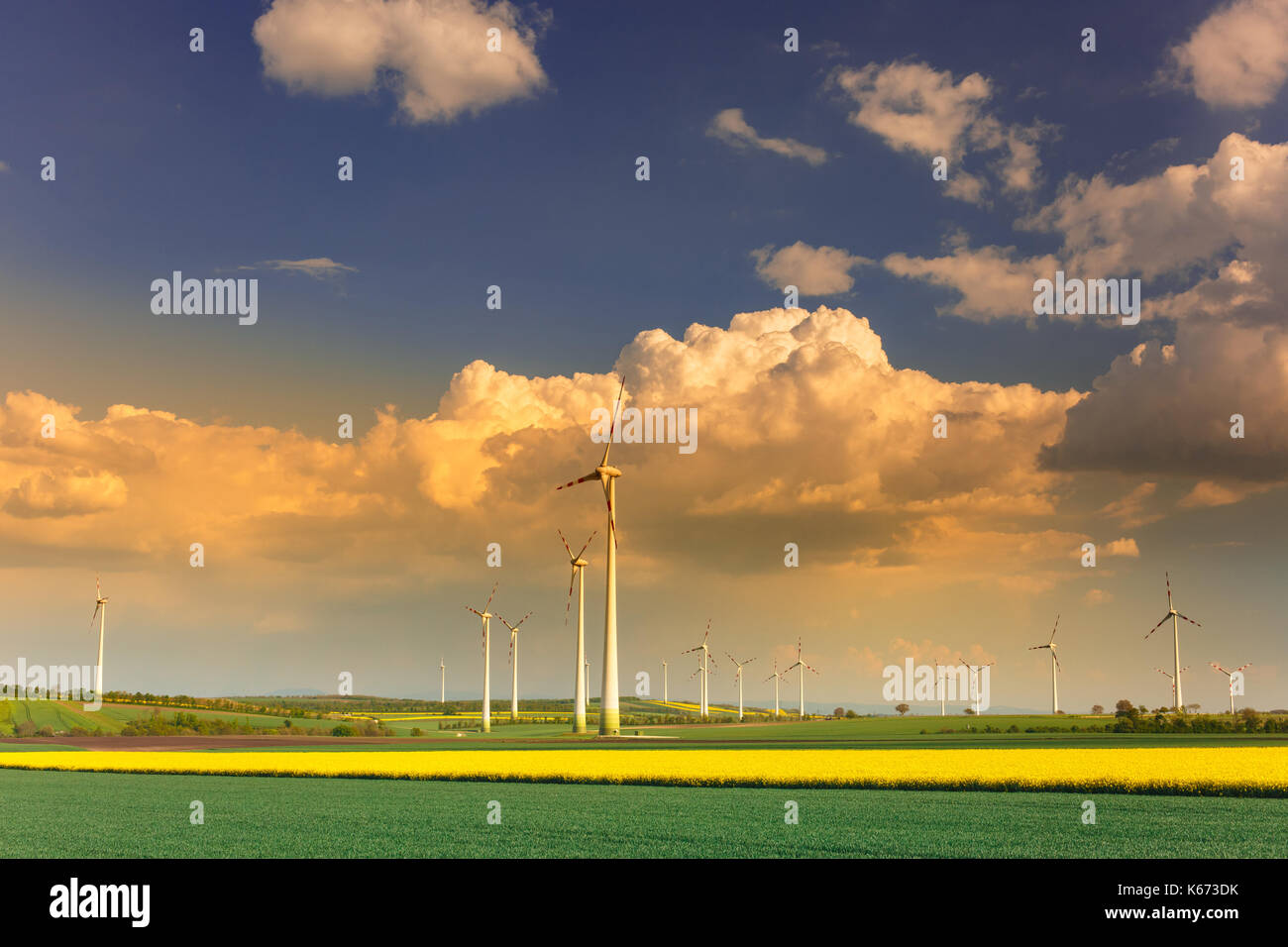 Wind farm with spinning wind turbines amidst agricultural land of ...