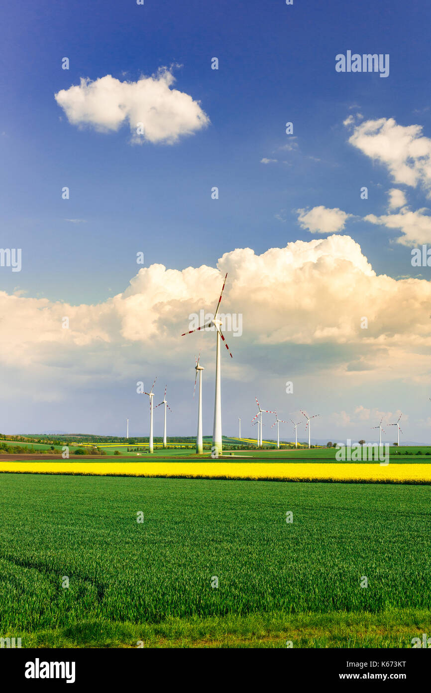 Wind farm with spinning wind turbines amidst agricultural land of ...