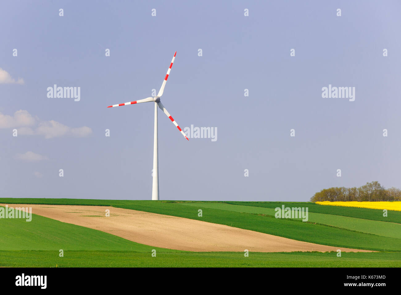 Wind farm with spinning wind turbine amidst agricultural land of ...