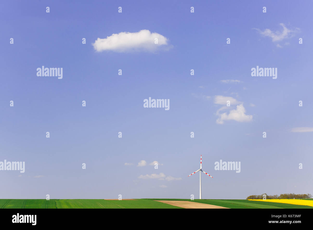 Wind farm with spinning wind turbine amidst agricultural land of ...