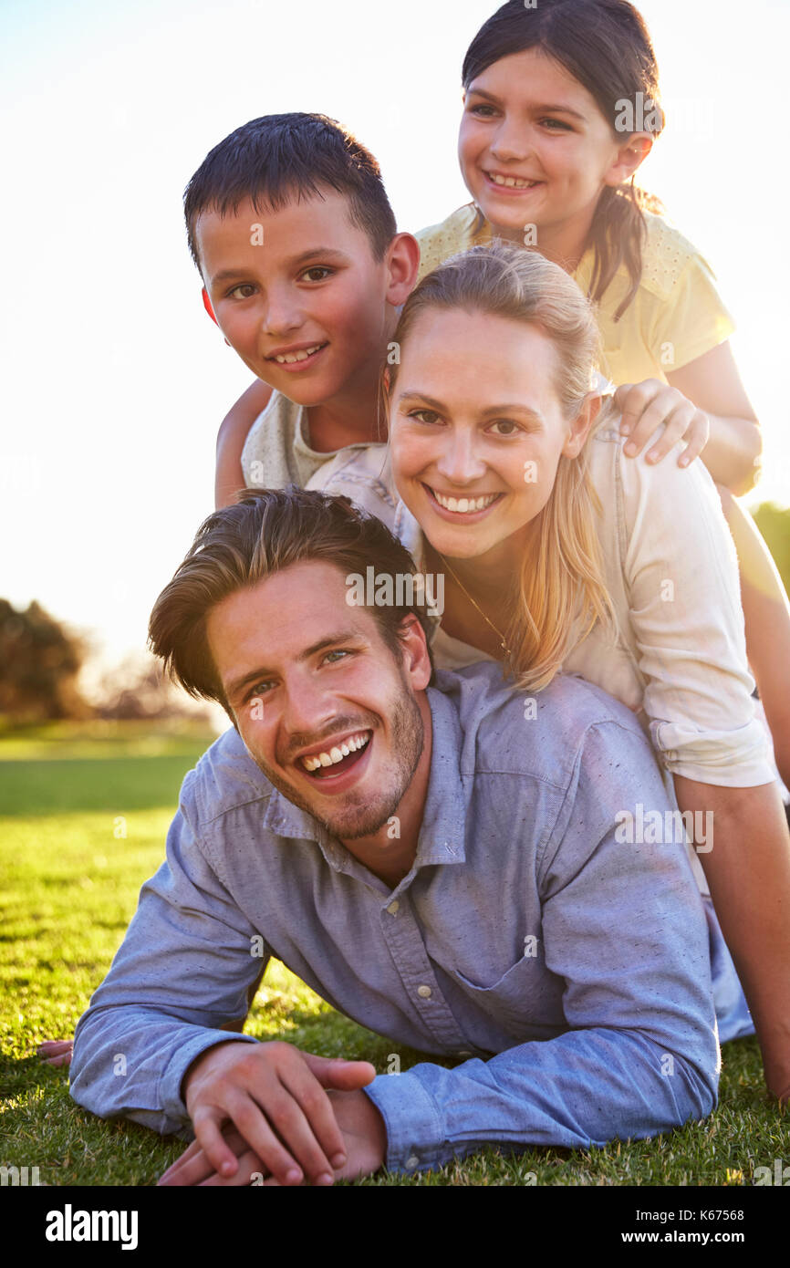 Happy white family lying in a pile on grass outdoors Stock Photo - Alamy