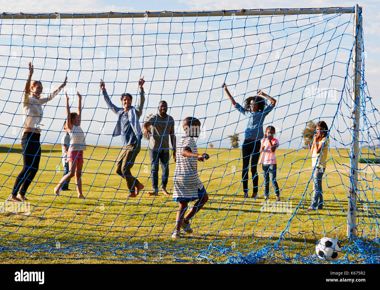Two families playing football in park celebrating a goal Stock Photo ...
