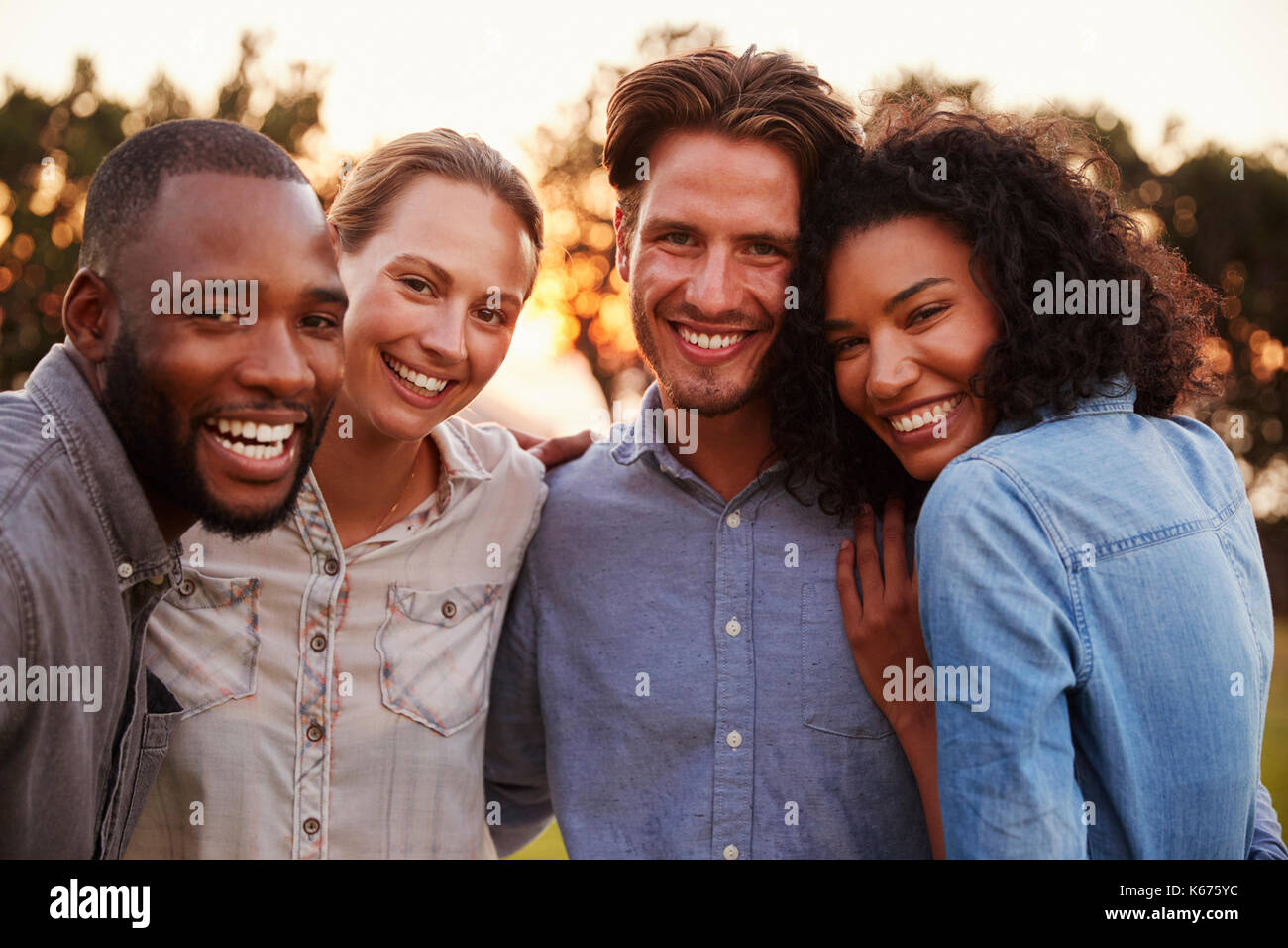 Portrait of two happy young couples smiling and embracing Stock Photo ...