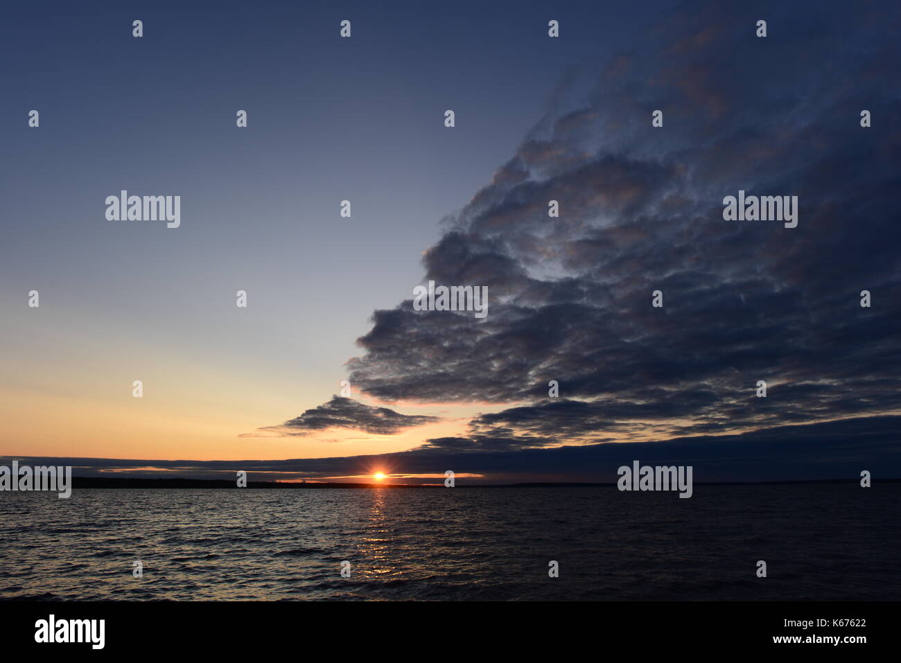 Flash of sun rays at sunset from behind clouds Stock Photo - Alamy