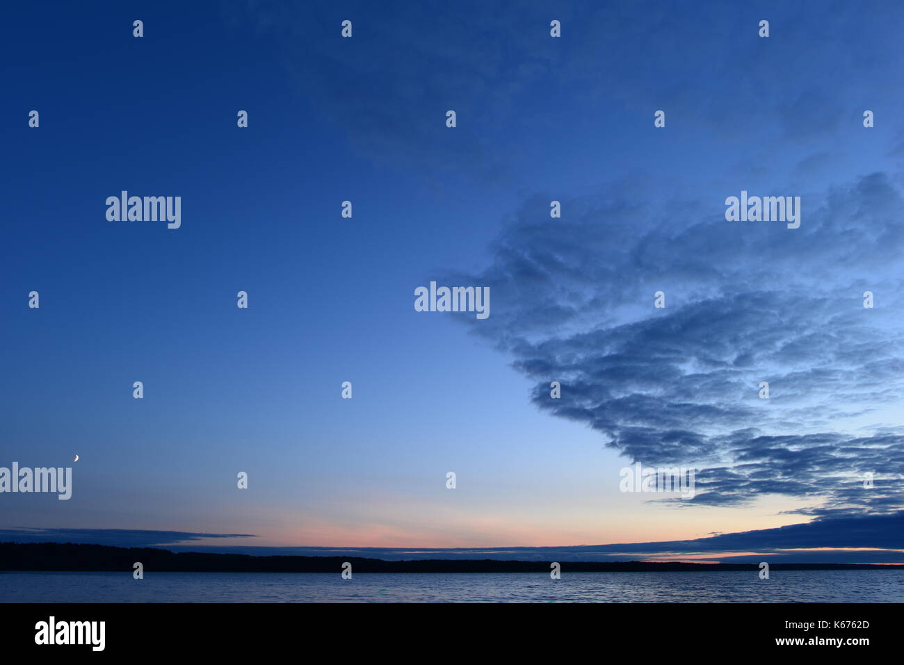 Twilight blue sky with a rising moon at sunset Stock Photo - Alamy