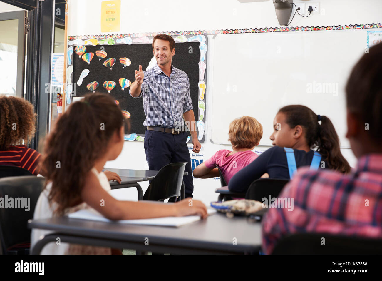 Teacher gesturing to class in an elementary school lesson Stock Photo ...