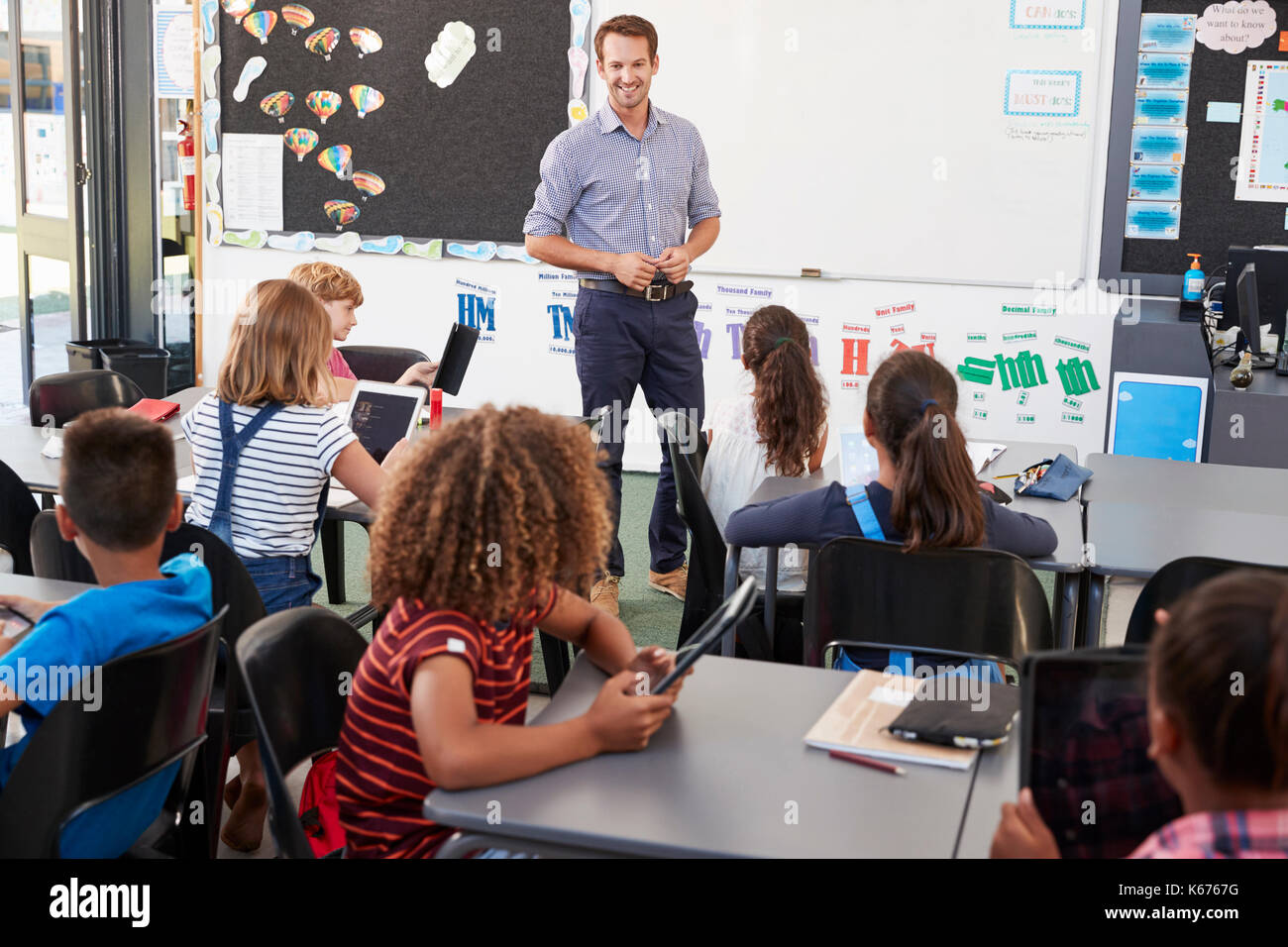 Teacher standing in front of elementary school class Stock Photo - Alamy