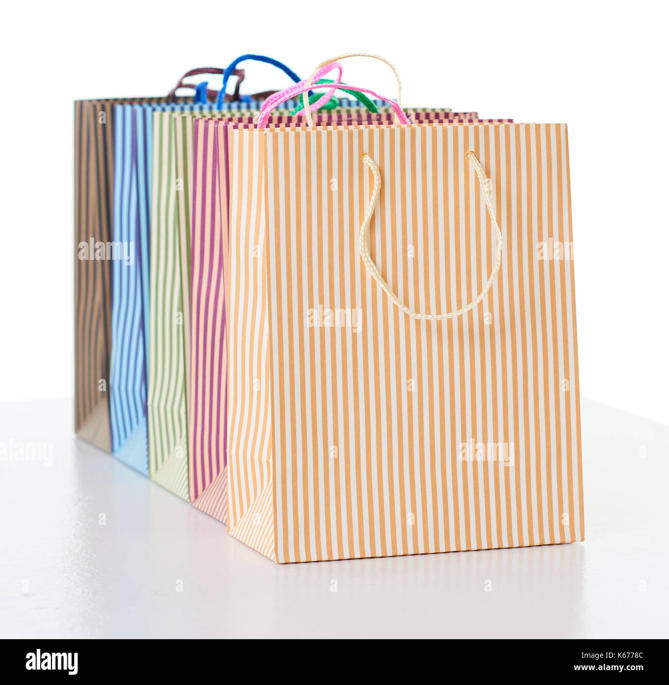 colorful striped shopping bags arranged in a row, object isolated on ...