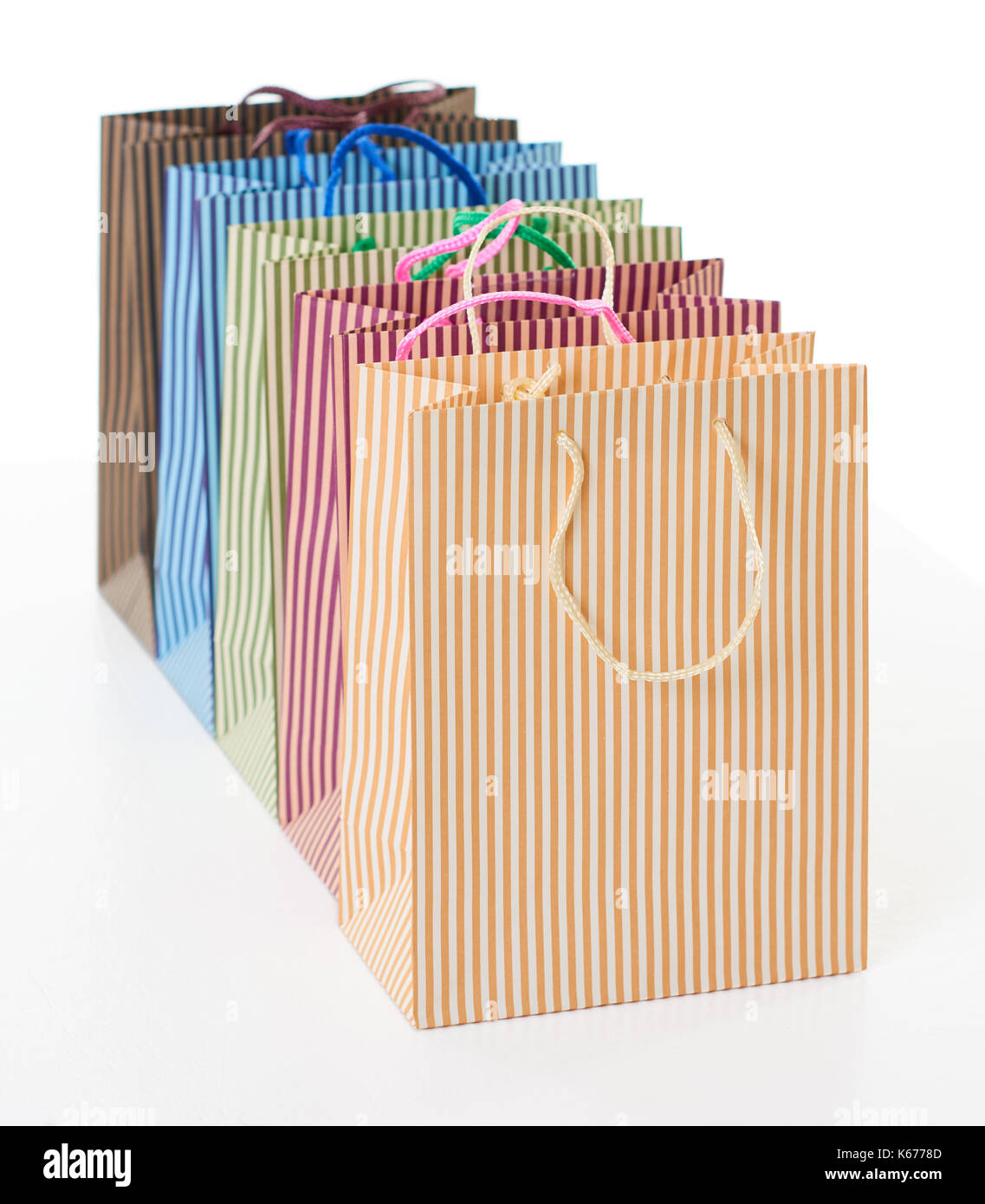 colorful striped shopping bags arranged in a row, object isolated on ...